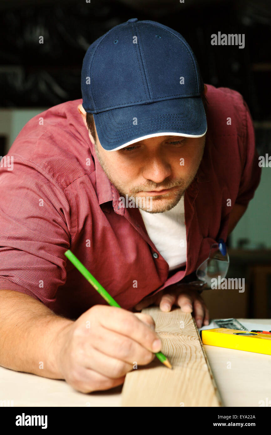 This is photo of professional carpenter at work measuring wooden planks ...