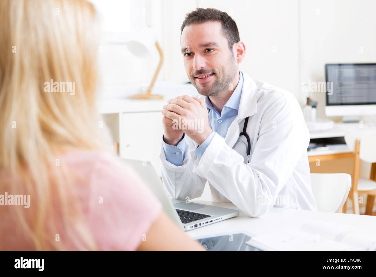 View of a Young attractive doctor listening his patient Stock Photo - Alamy