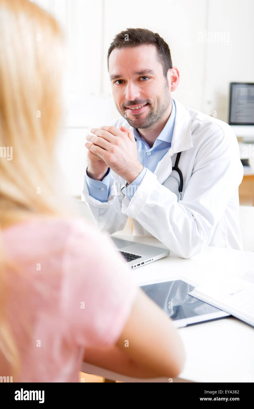View of a Young attractive doctor listening his patient Stock Photo - Alamy