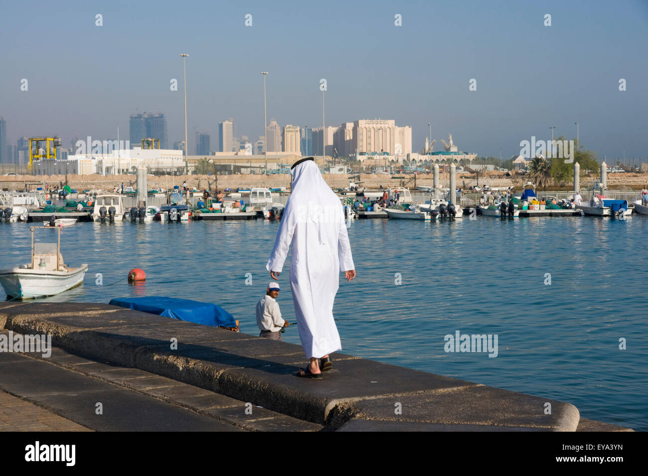 Man in traditional gown and doha bay skyline hi-res stock photography ...