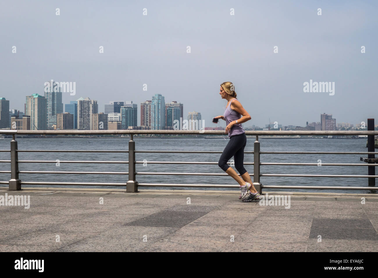 Woman running, jogging at Hudson river park. Manhattan, Jersey city in ...