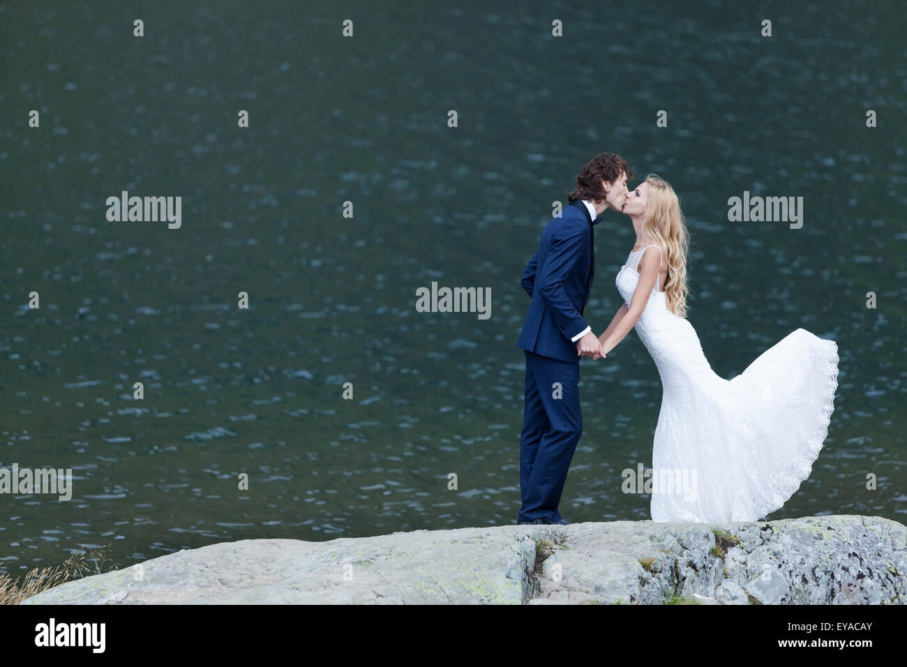 Married couple kissing nears a lake, acting romantic and joyful Stock ...