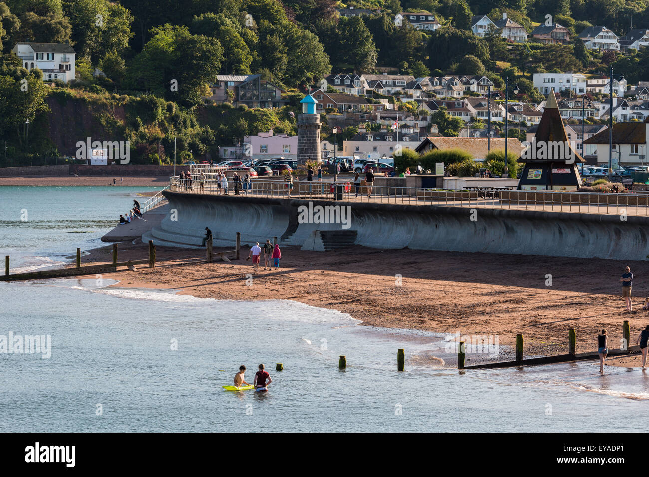 Swimmers on the seaside beach at Teignmouth, Devon. The lighthouse and ...