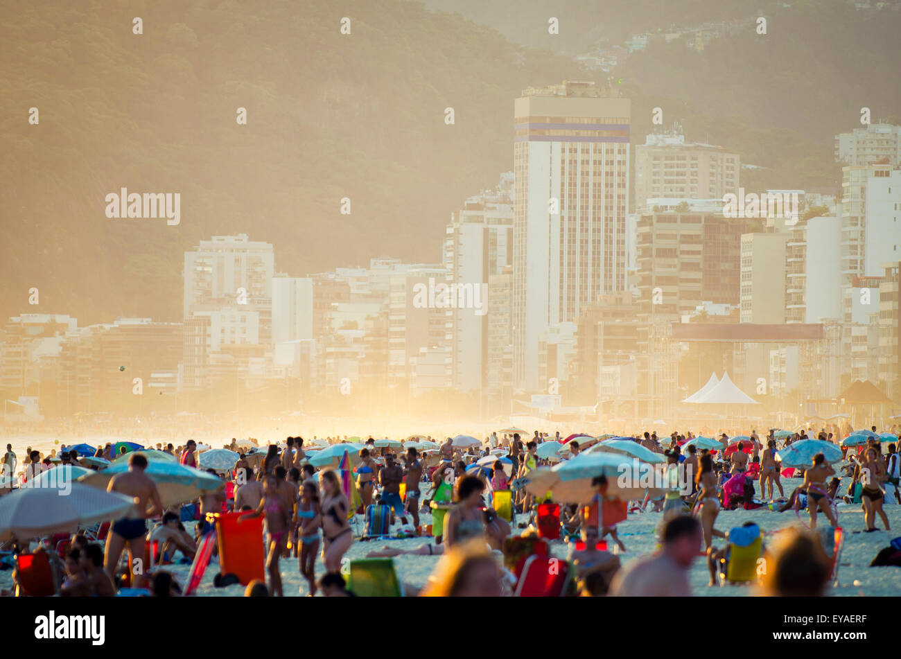 Busy crowded afternoon on Ipanema Beach during a misty sunset in Rio de ...