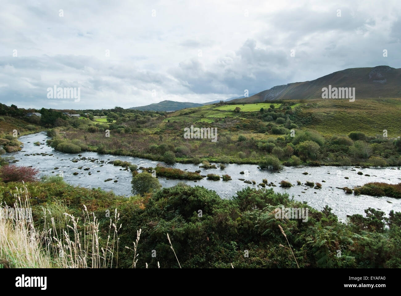 A Stream Running Through The Landscape With Mountains In The Distance ...