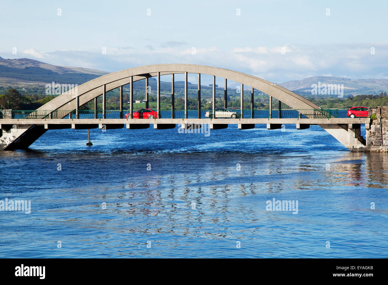 An arched road bridge crossing water with traffic; Kenmare, County ...