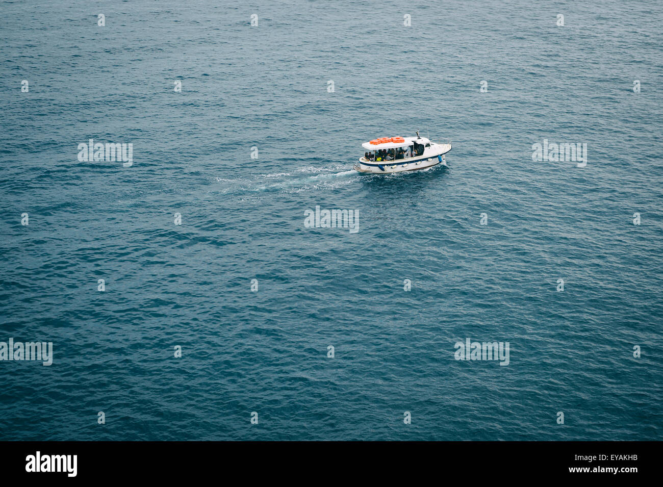 Sightseeing ferry boat traveling across wide blue ocean background in ...