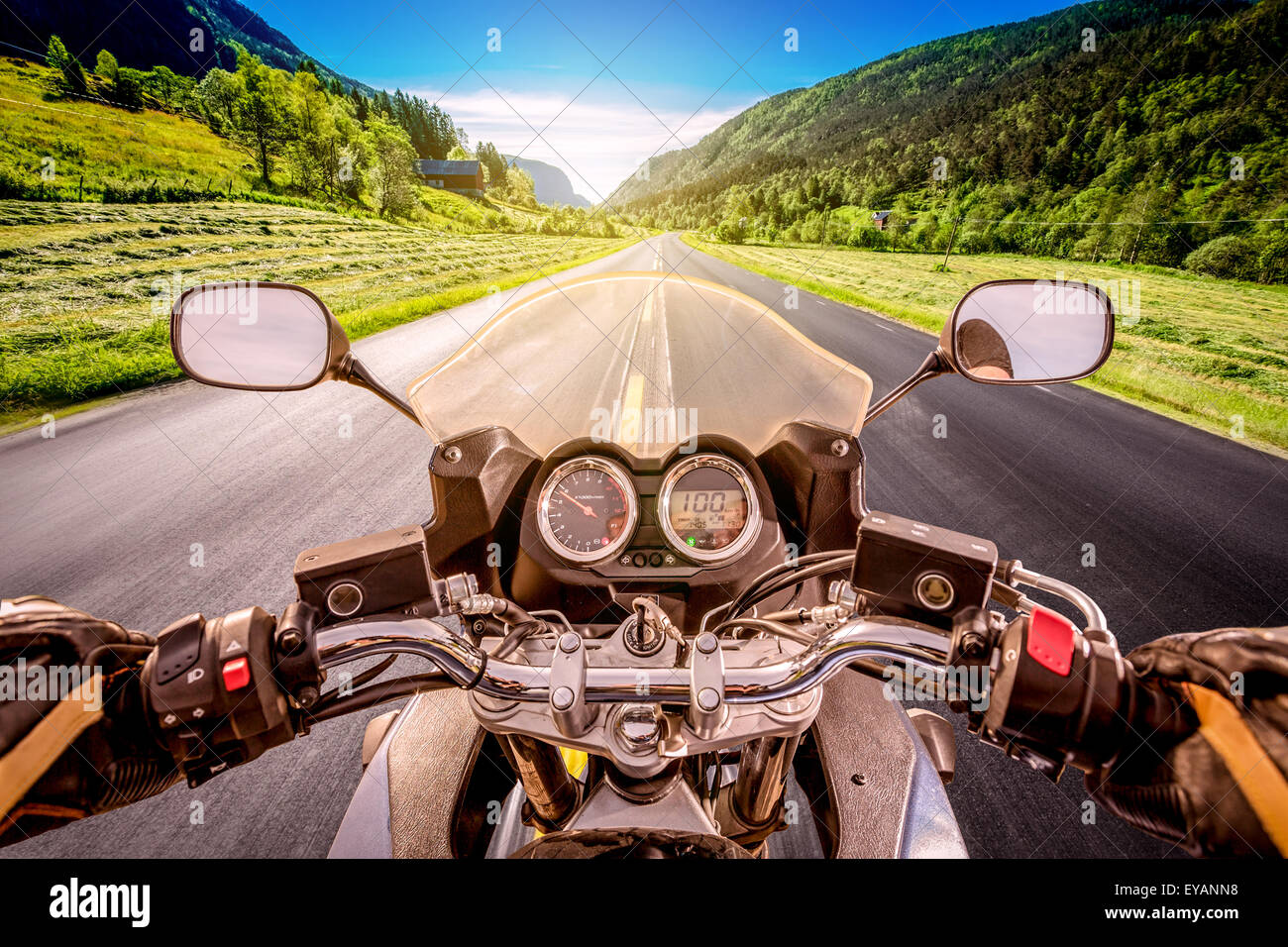 Biker driving a motorcycle rides along the asphalt road. First-person ...