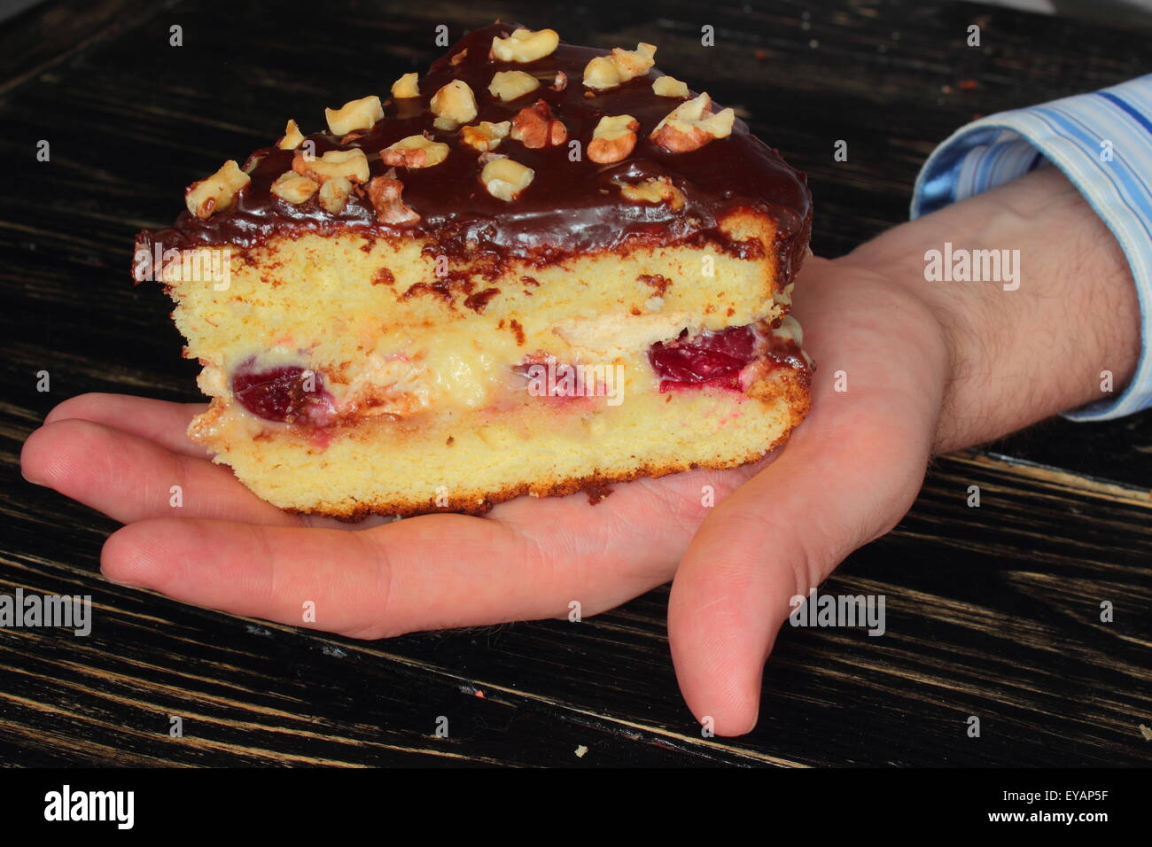 In his hand is a piece of chocolate cake Stock Photo - Alamy