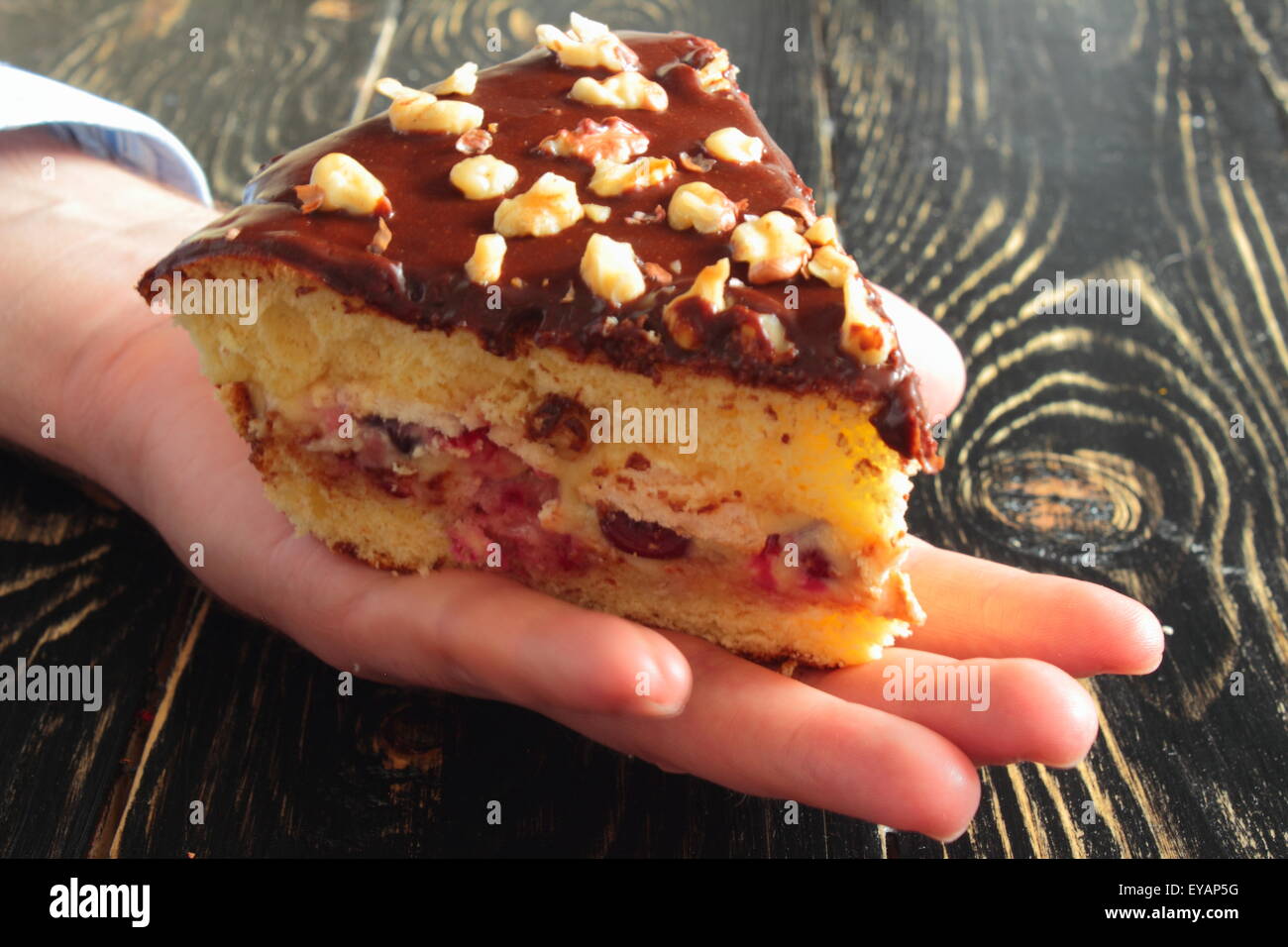 In his hand is a piece of chocolate cake Stock Photo - Alamy