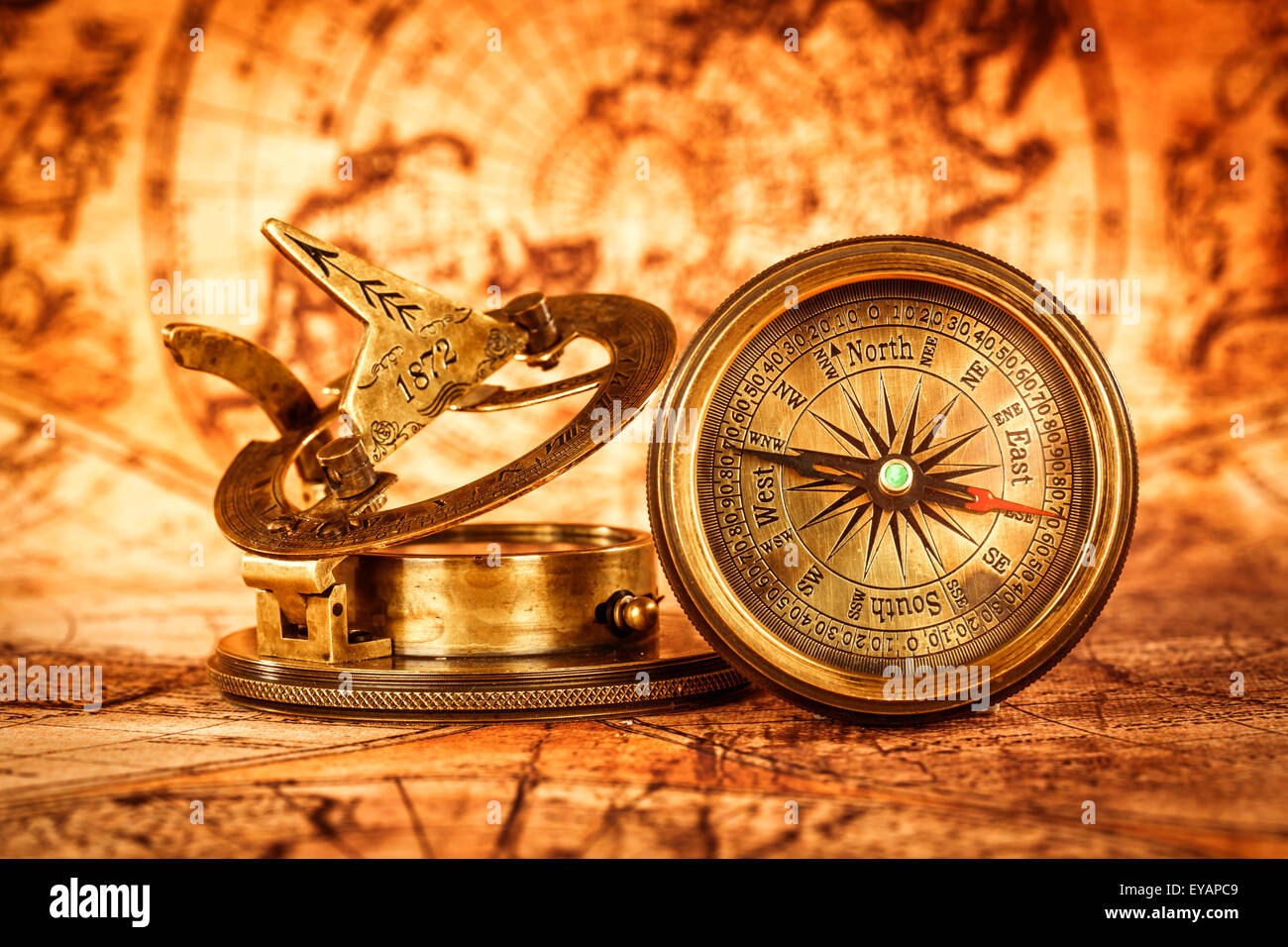Vintage still life. Vintage compass lies on an ancient world map in ...