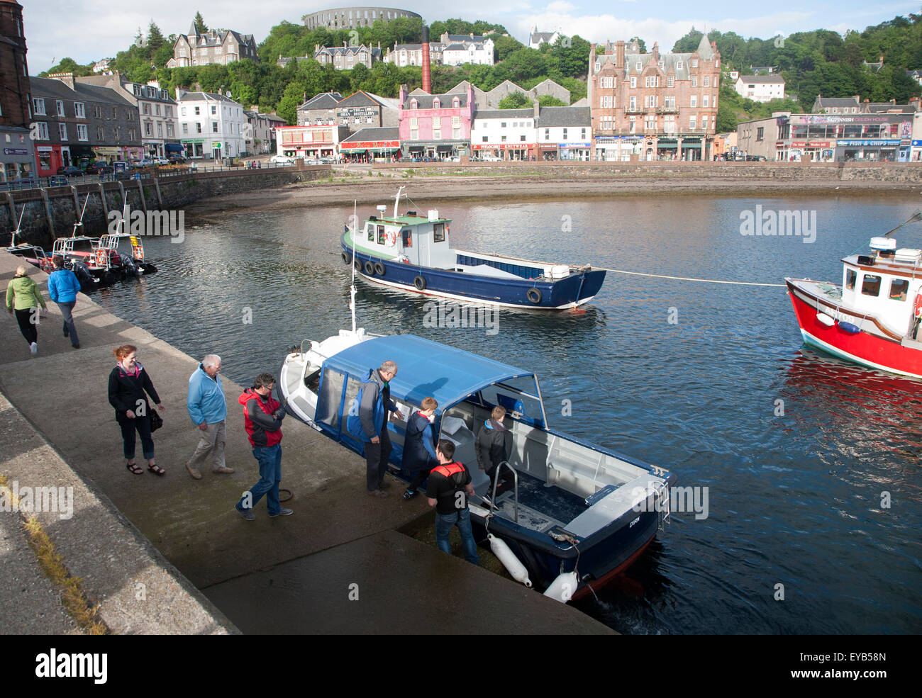 Fishing boats and small passenger foot ferry in the harbour at the town ...