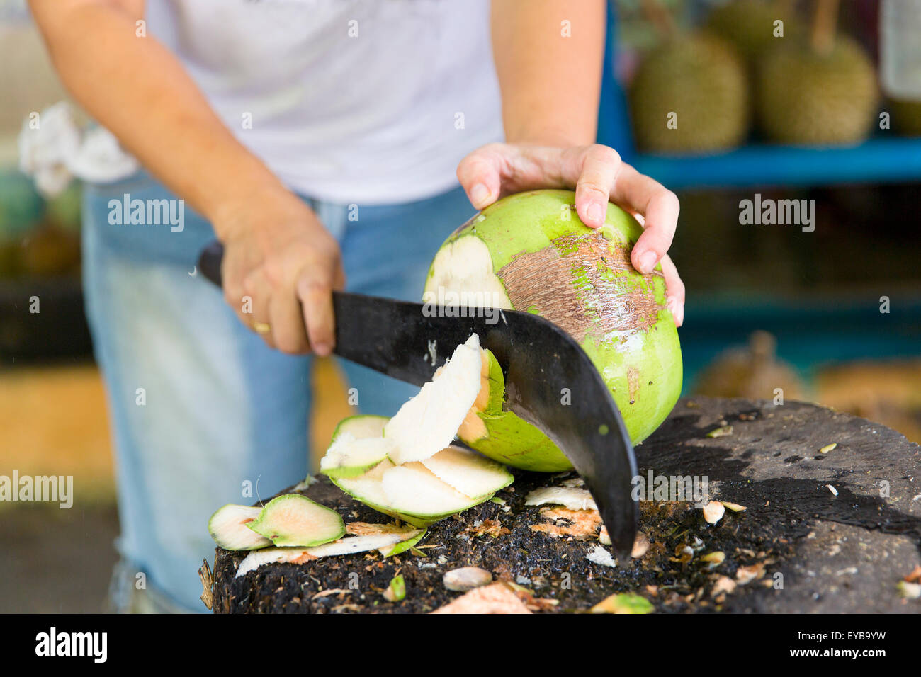 Woman cutting fresh coconut at the market Stock Photo - Alamy
