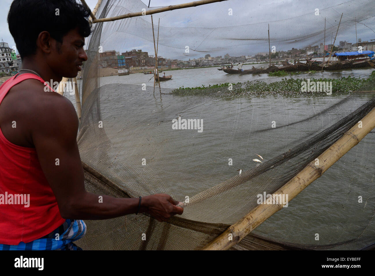Dhaka, Bangladesh. 26th July, 2015. A Bangladeshi fisherman busy to ...