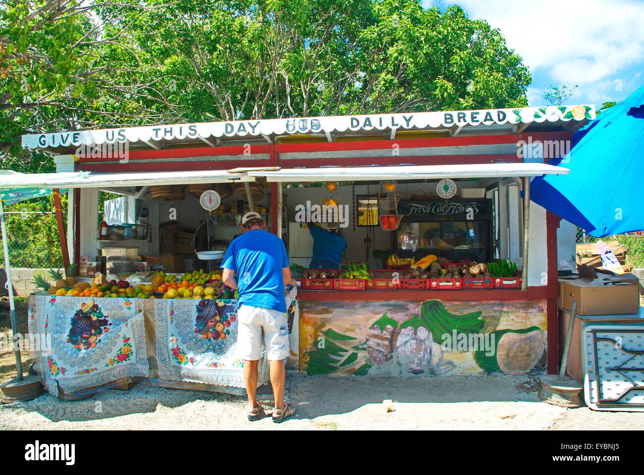 Man buying fresh produce from roadside market stand selling fruits and ...