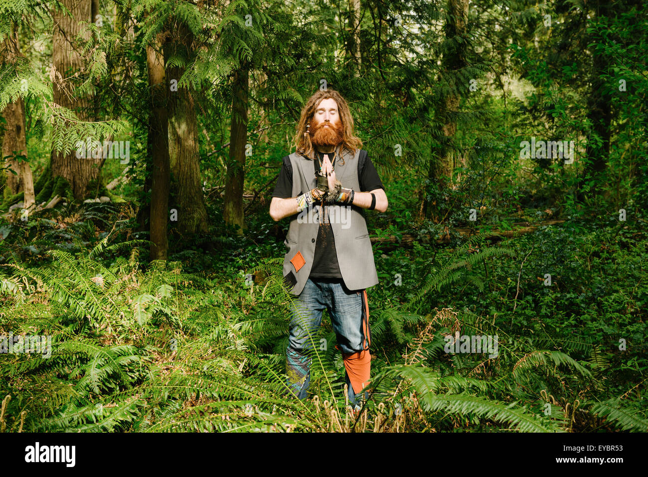 A hippy man meditating in the forest Stock Photo - Alamy
