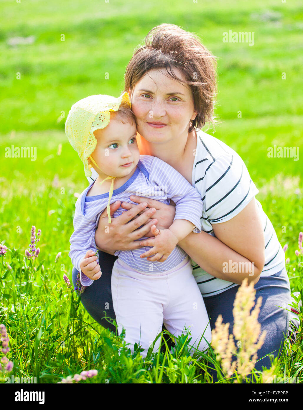 Portrait of 1 year old baby girl with her mother on a meadow Stock ...