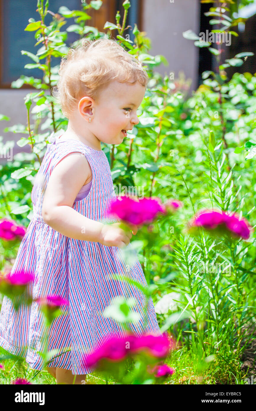 Portrait of 1 year old baby girl in the flower garden at home Stock ...