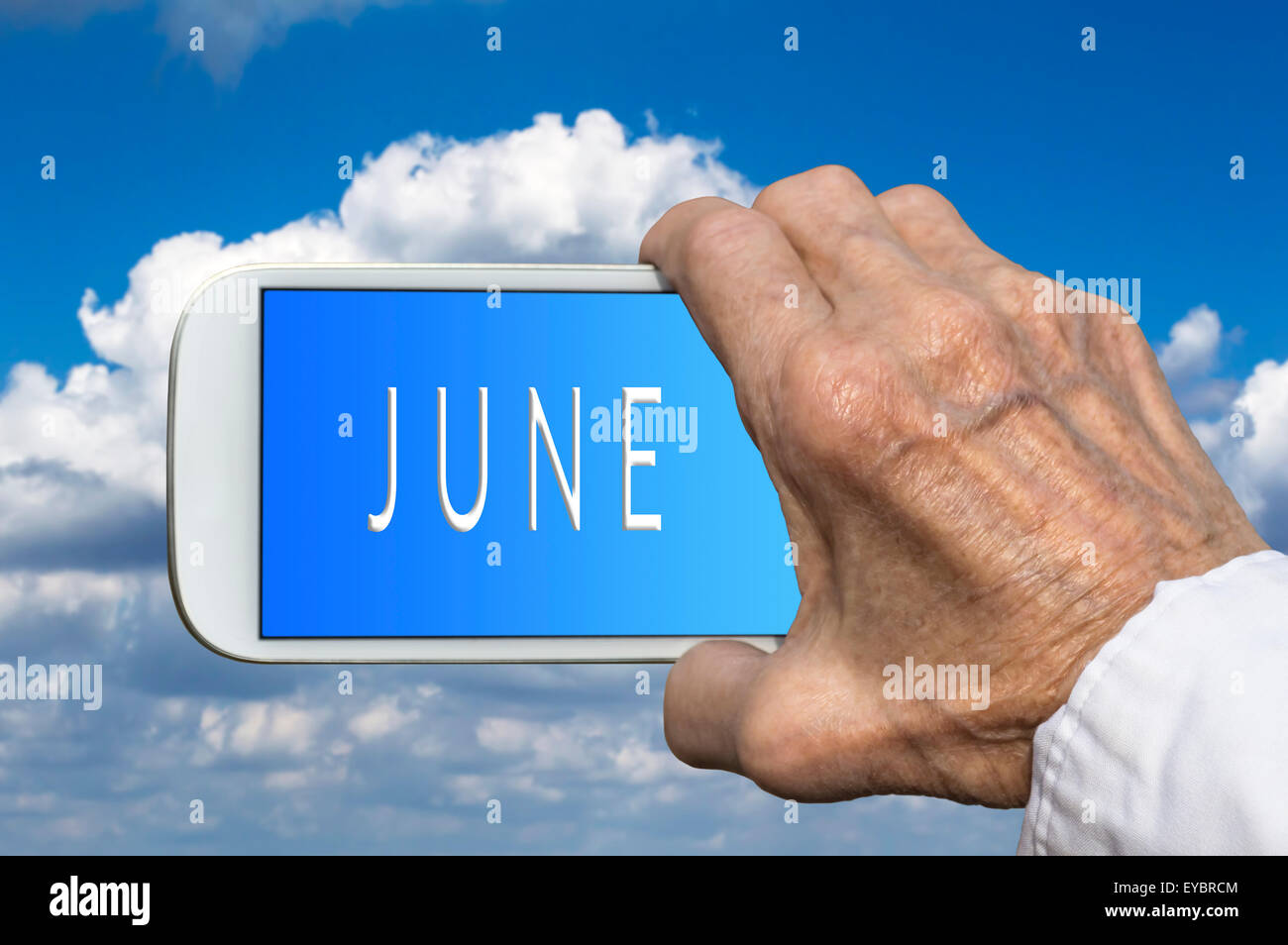 Smart phone in old hand with month of the year - June on screen ...