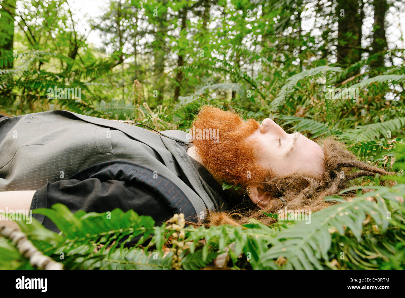 A hippy man daydreaming in the forest Stock Photo - Alamy
