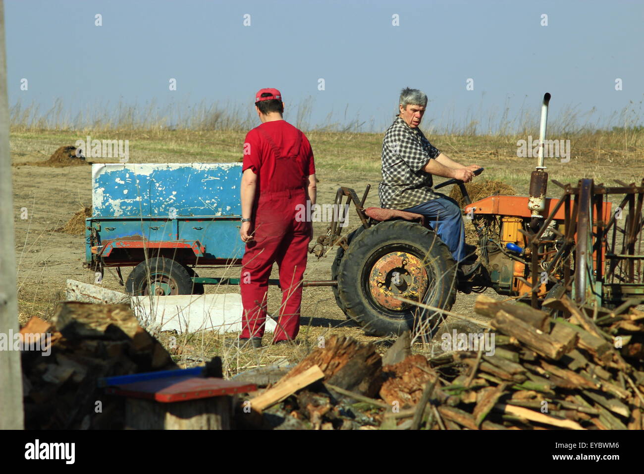 rural men work with tractor with trailer in the village Stock Photo - Alamy