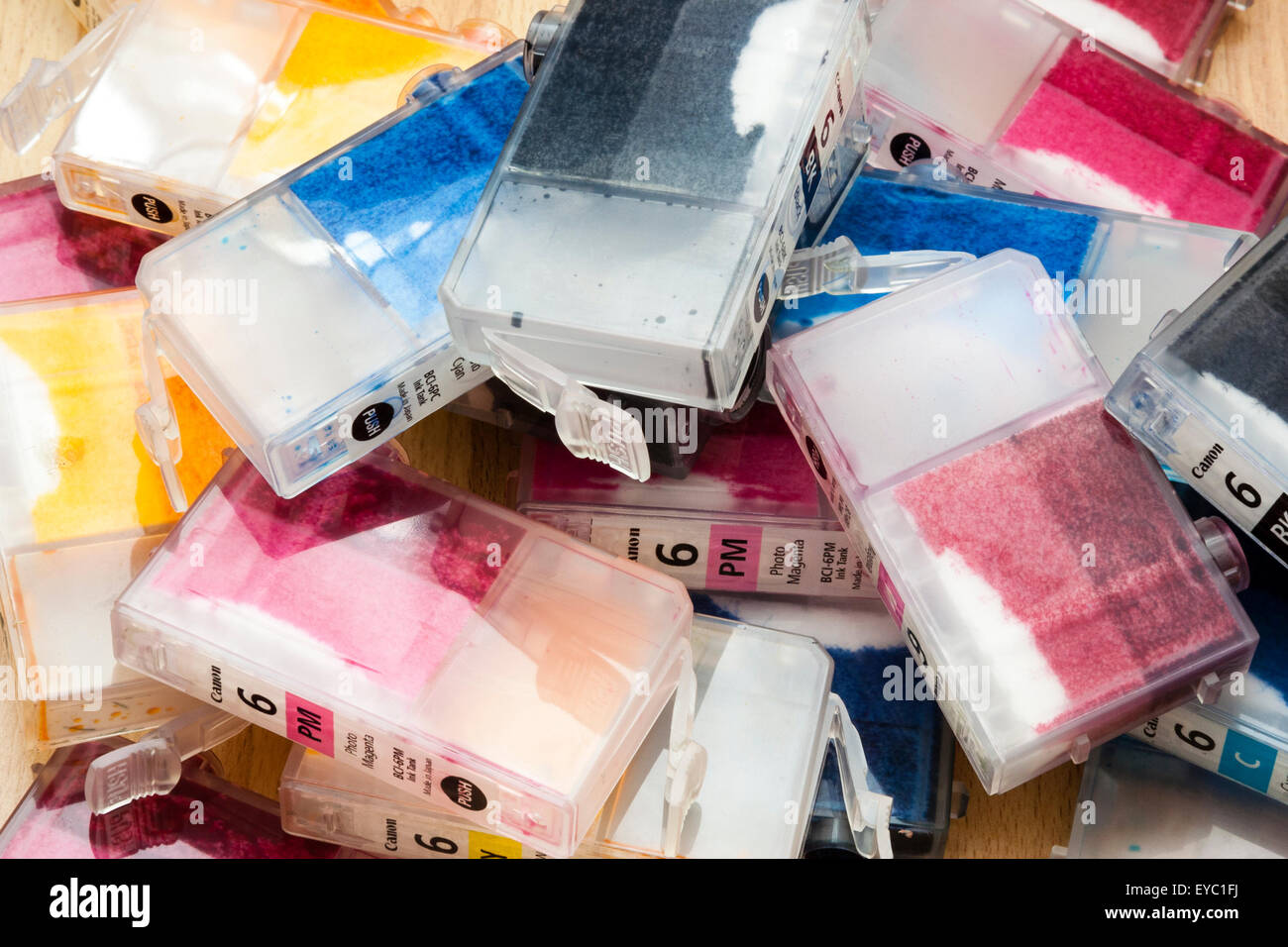 Scattered empty used ink jet printer cartridges of various colored inks ...