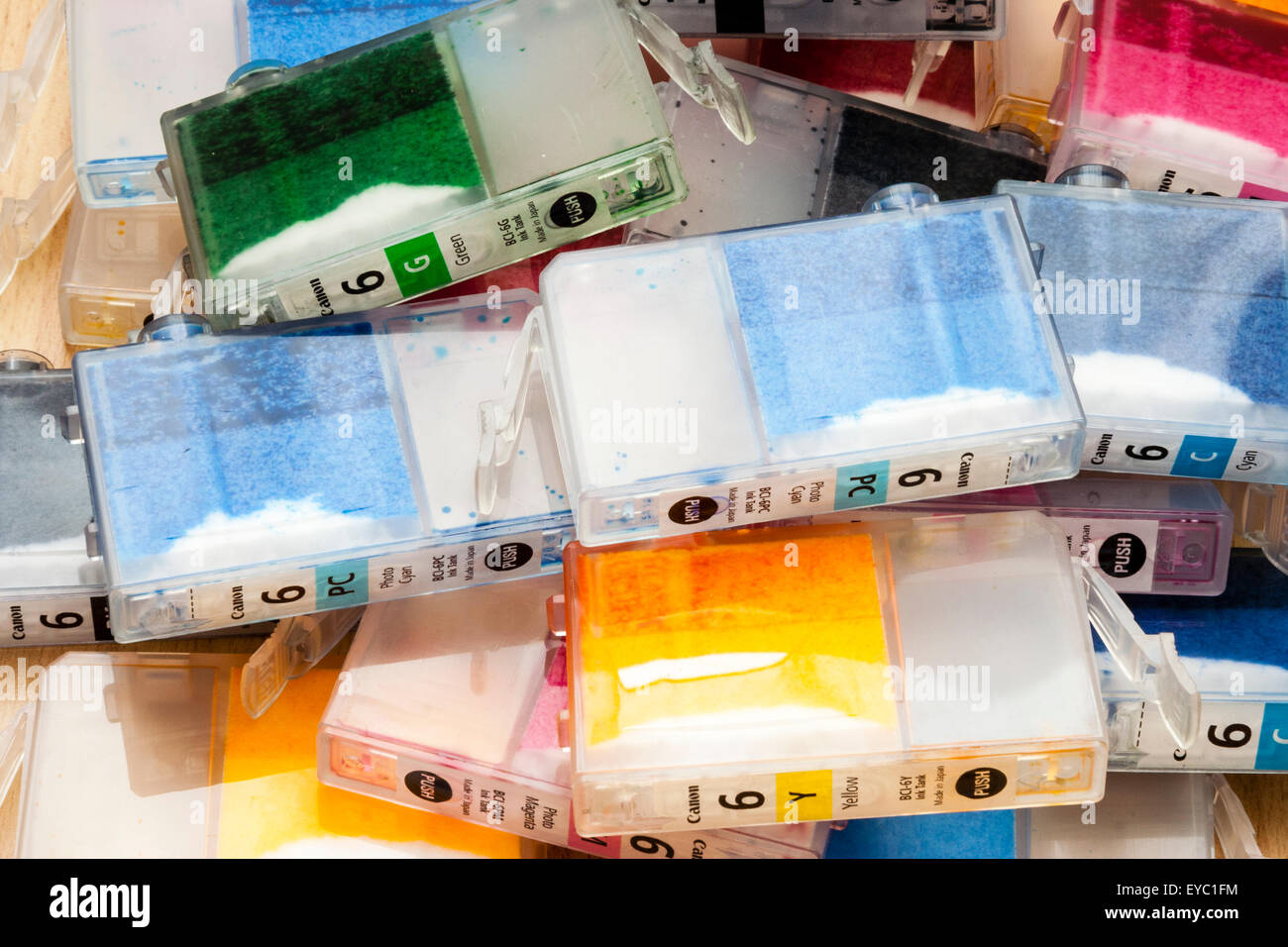 Scattered empty used ink jet printer cartridges of various colored inks ...