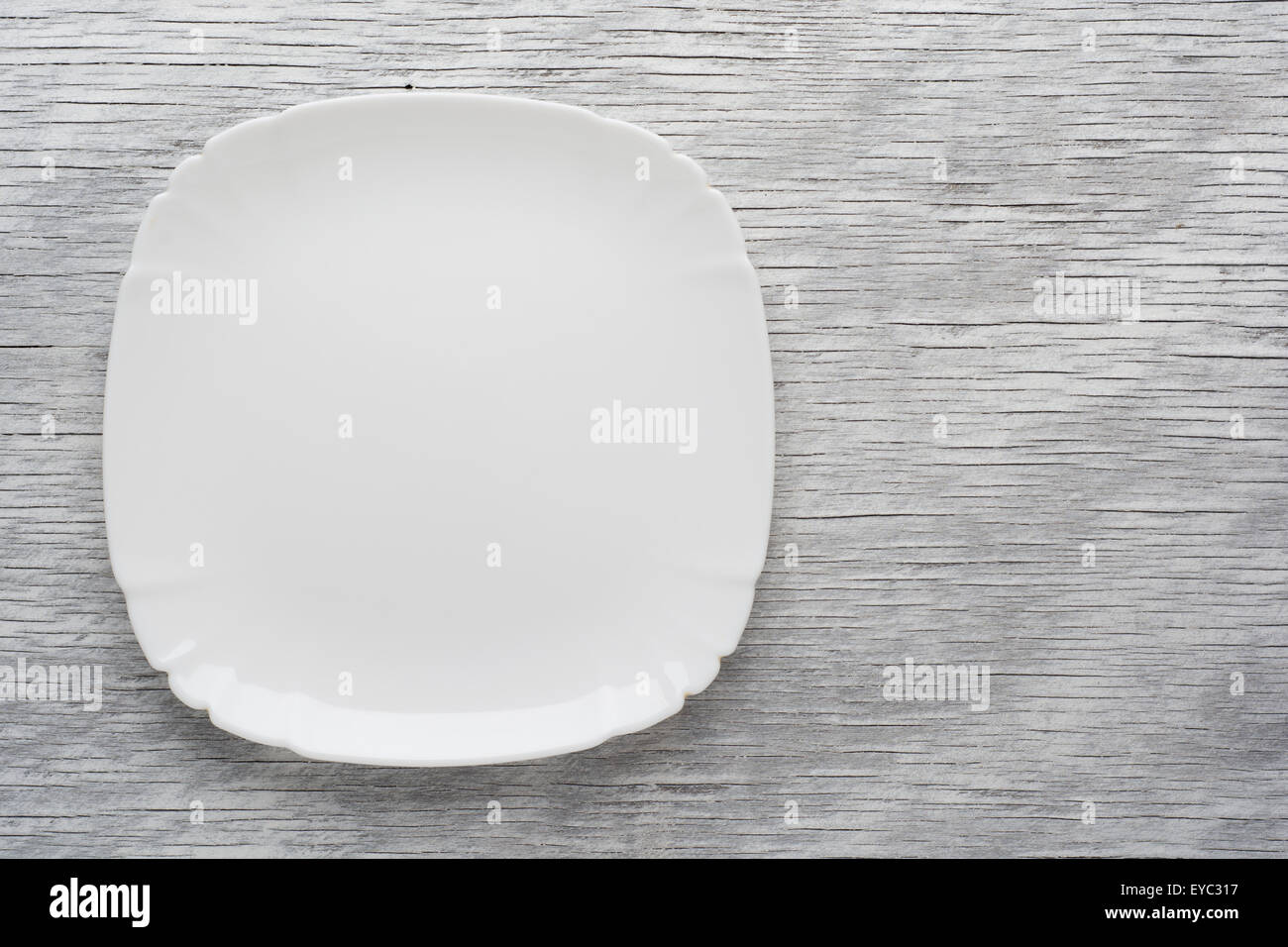 Empty white plate on wooden table Stock Photo - Alamy