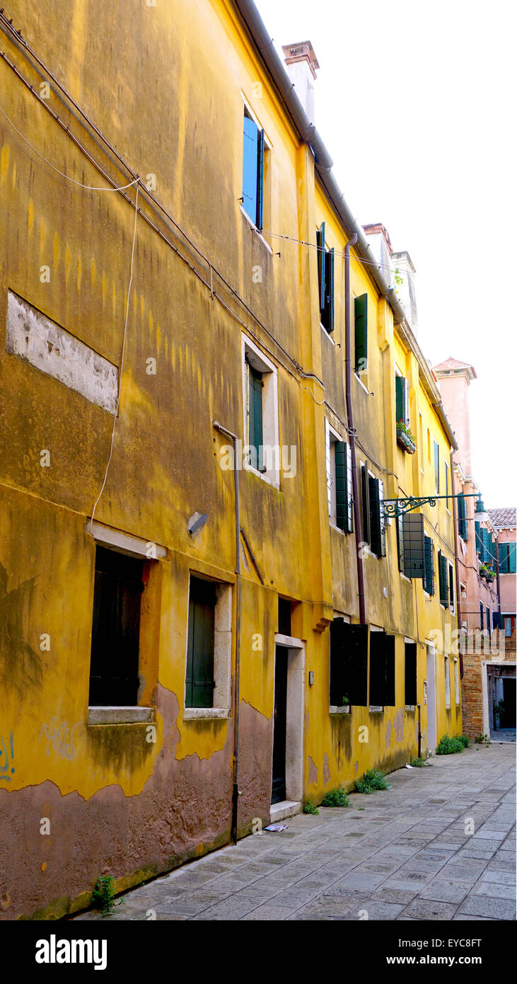 Alley with ancient yellow decay wall building in Venice, Italy Stock ...