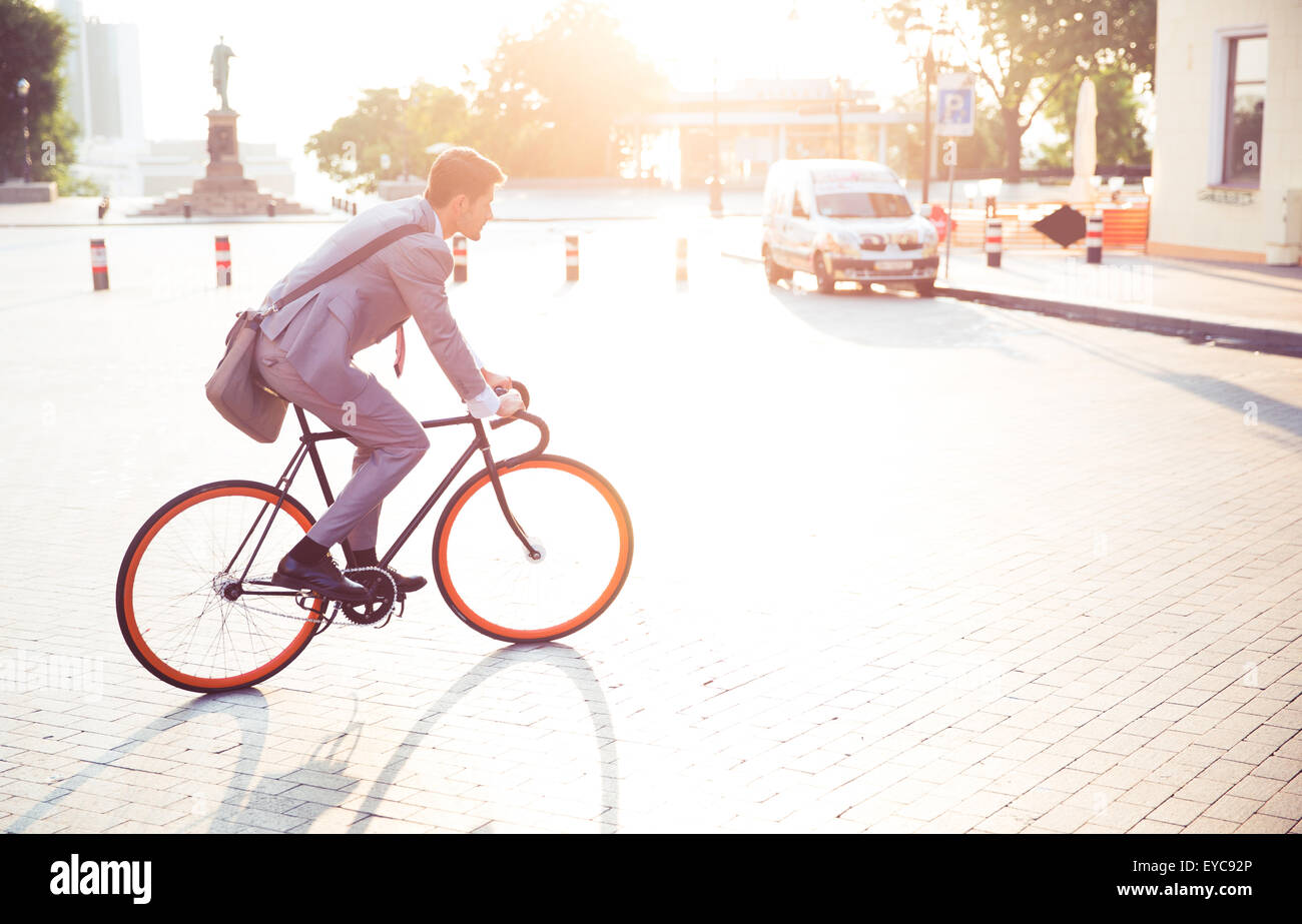Businessman riding bicycle to work in town Stock Photo - Alamy