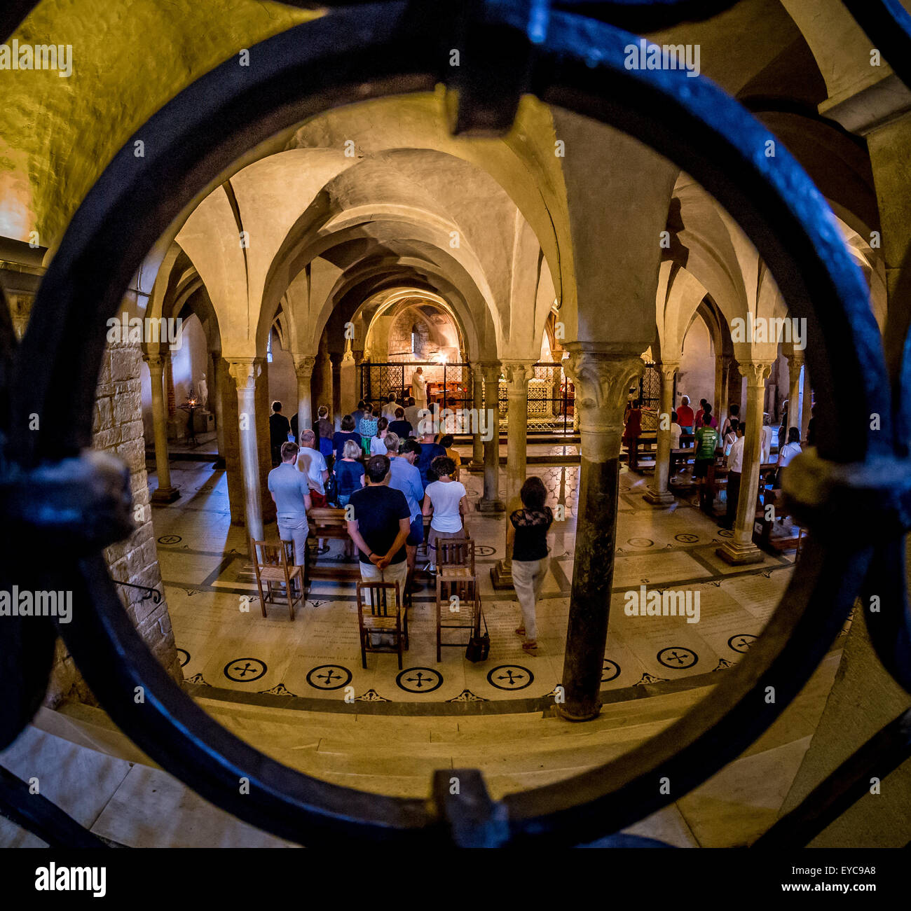 Church service seen through the metal screen of the crypt of San ...
