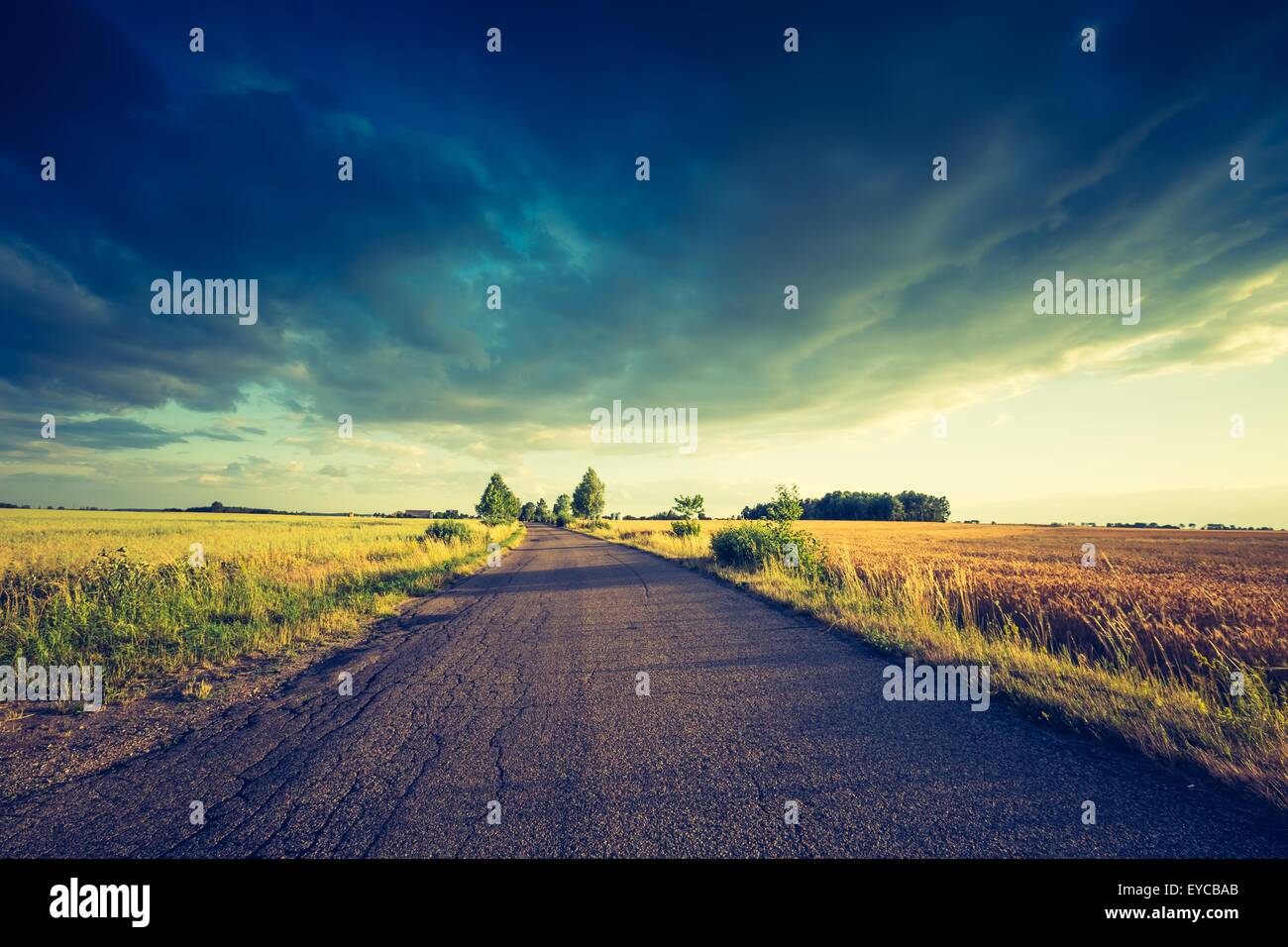Vintage photo of rural summer landscape with old asphalt road and ...