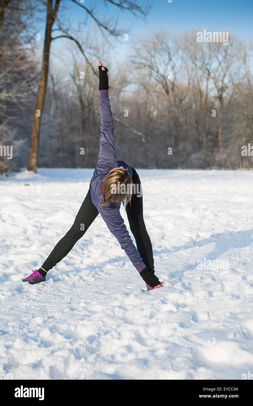 Young woman stretching in snow Stock Photo - Alamy