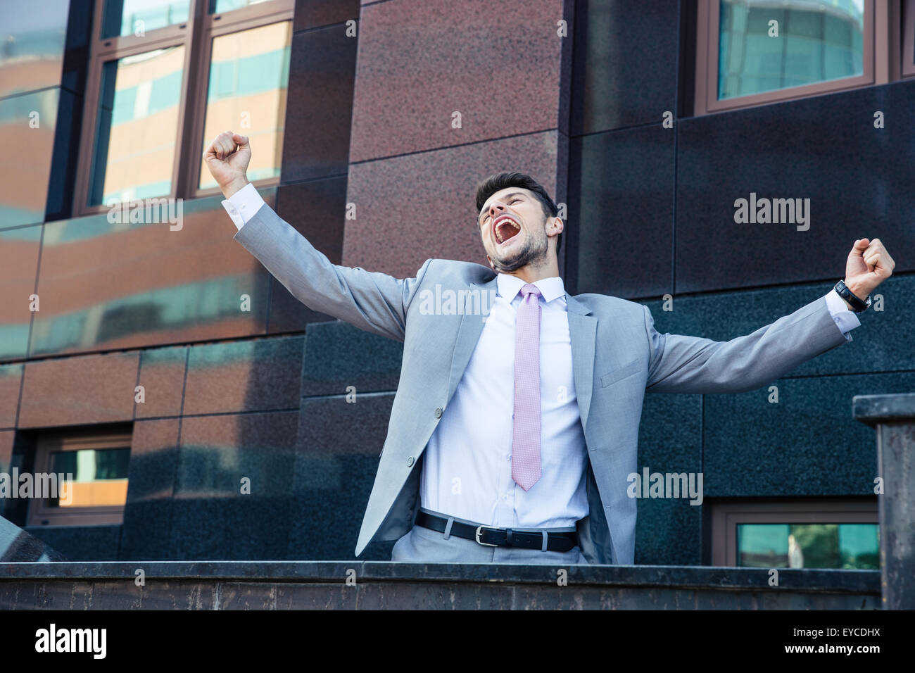 Cheerful businessman celebrating his success and screaming outdoors ...