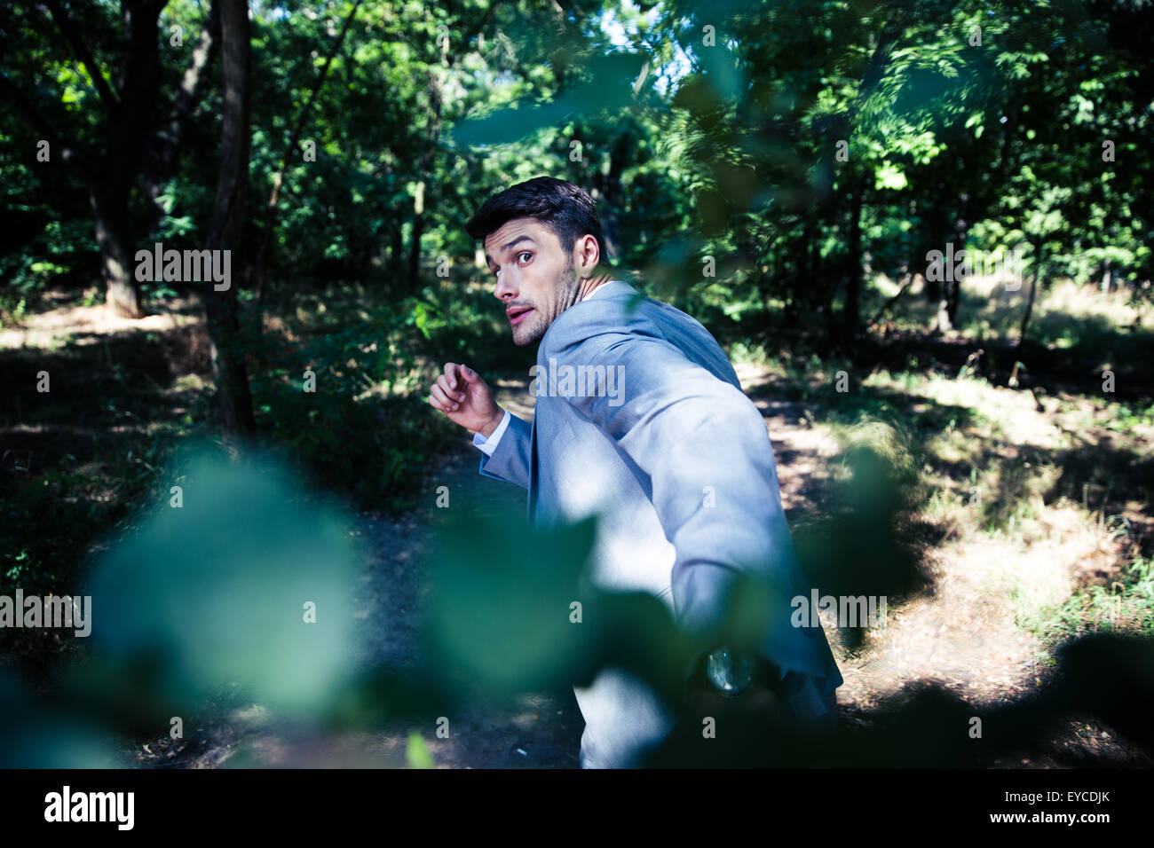 Afraid businessman running away from something outdoors in park Stock ...