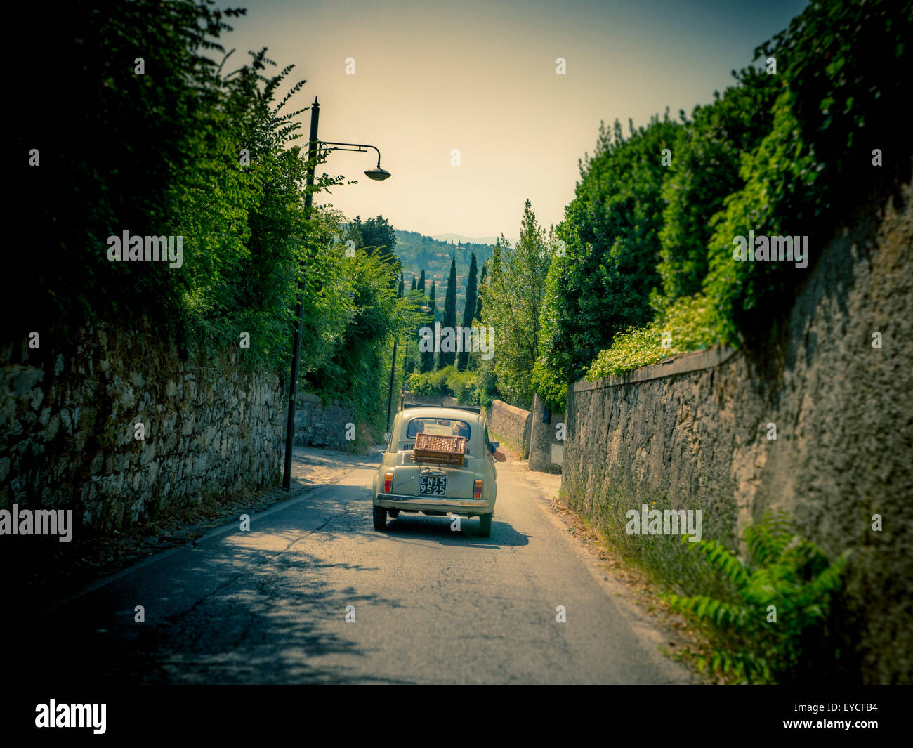 Classic Fiat 500 car driving on a road in Florence, Italy. Shot from ...