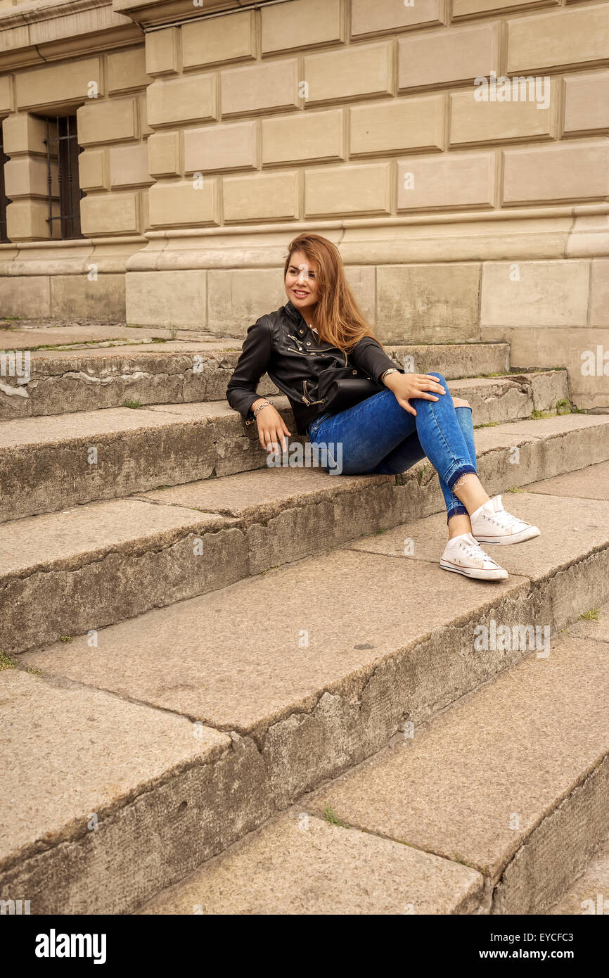 Portrait of a happy woman sitting on steps Stock Photo - Alamy