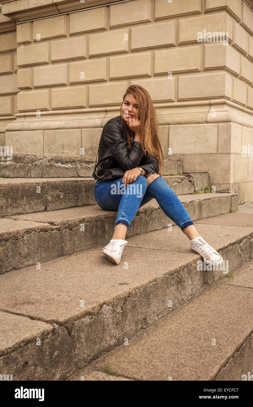 Portrait of a happy woman sitting on steps Stock Photo - Alamy