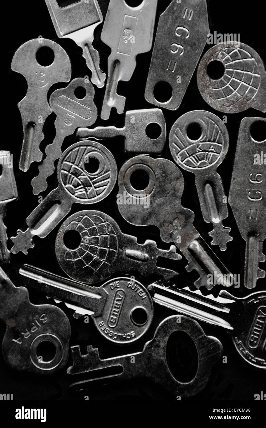 Different silver keys on black ground Stock Photo - Alamy