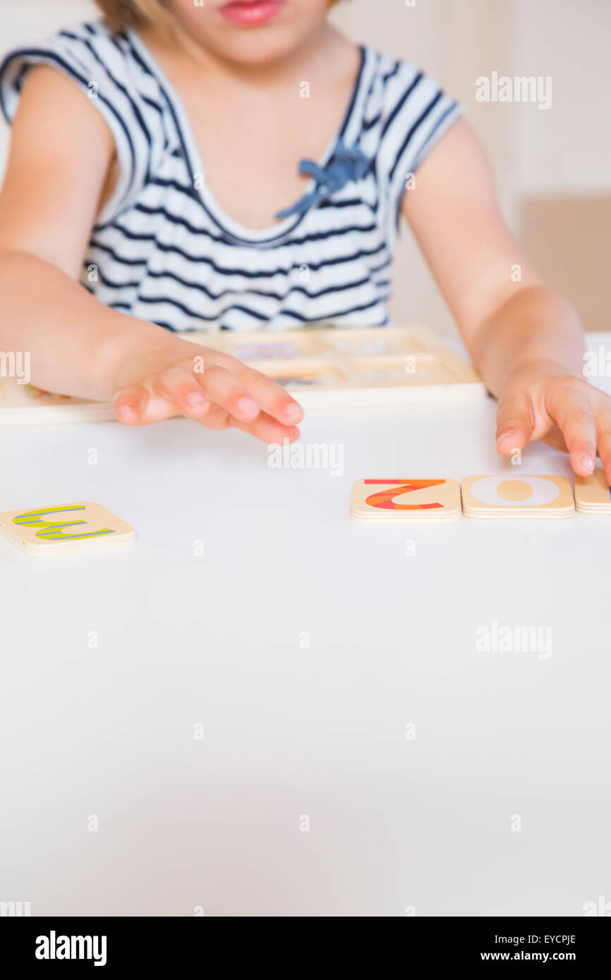 Little girl learning figures with wooden toys Stock Photo - Alamy