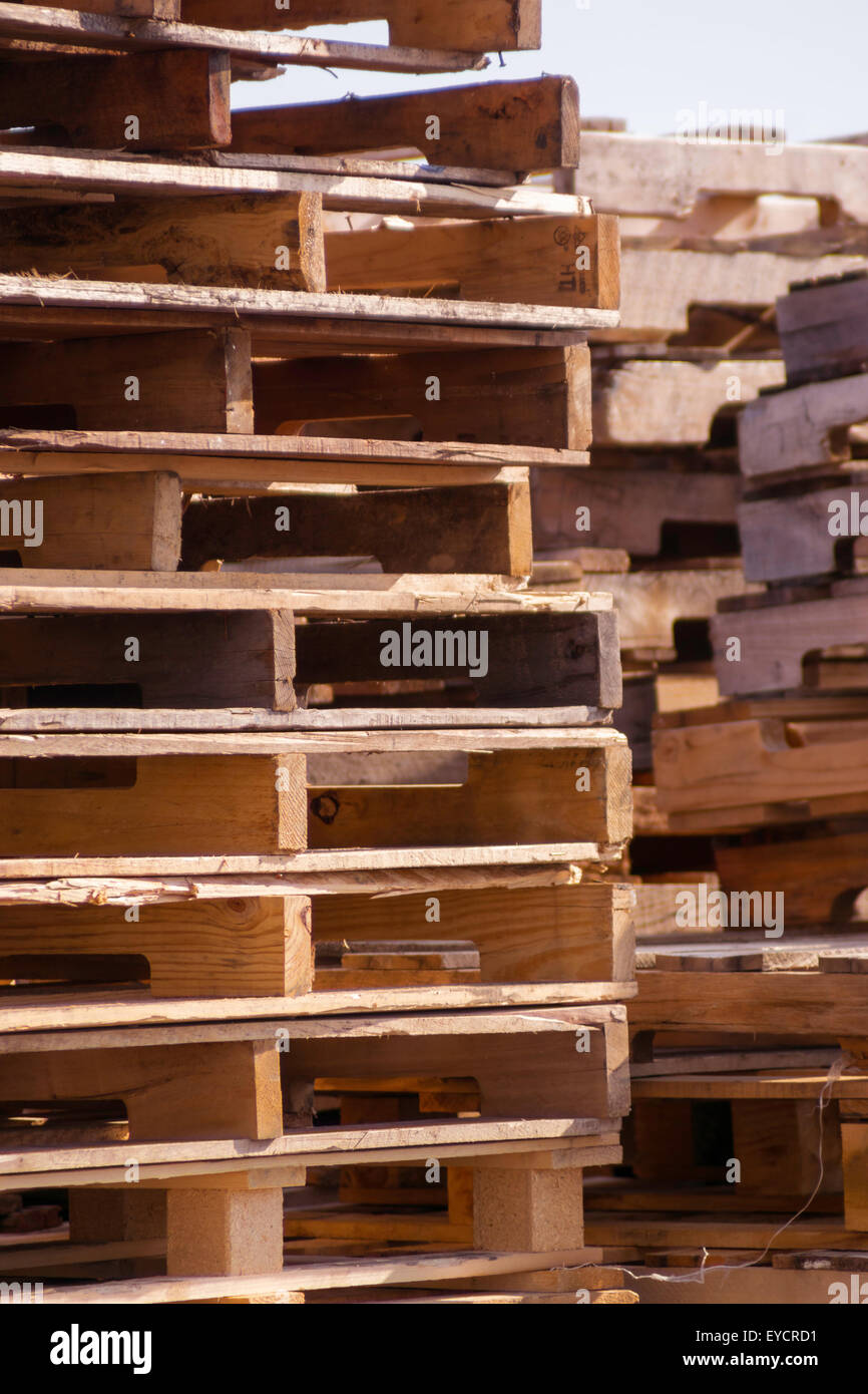 Several stacks of wooden pallets fill this outdoor image Stock Photo ...