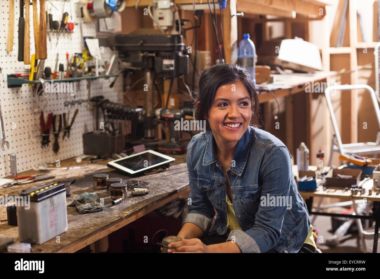 Portrait of female mechanic in workshop, looking away, smiling Stock ...