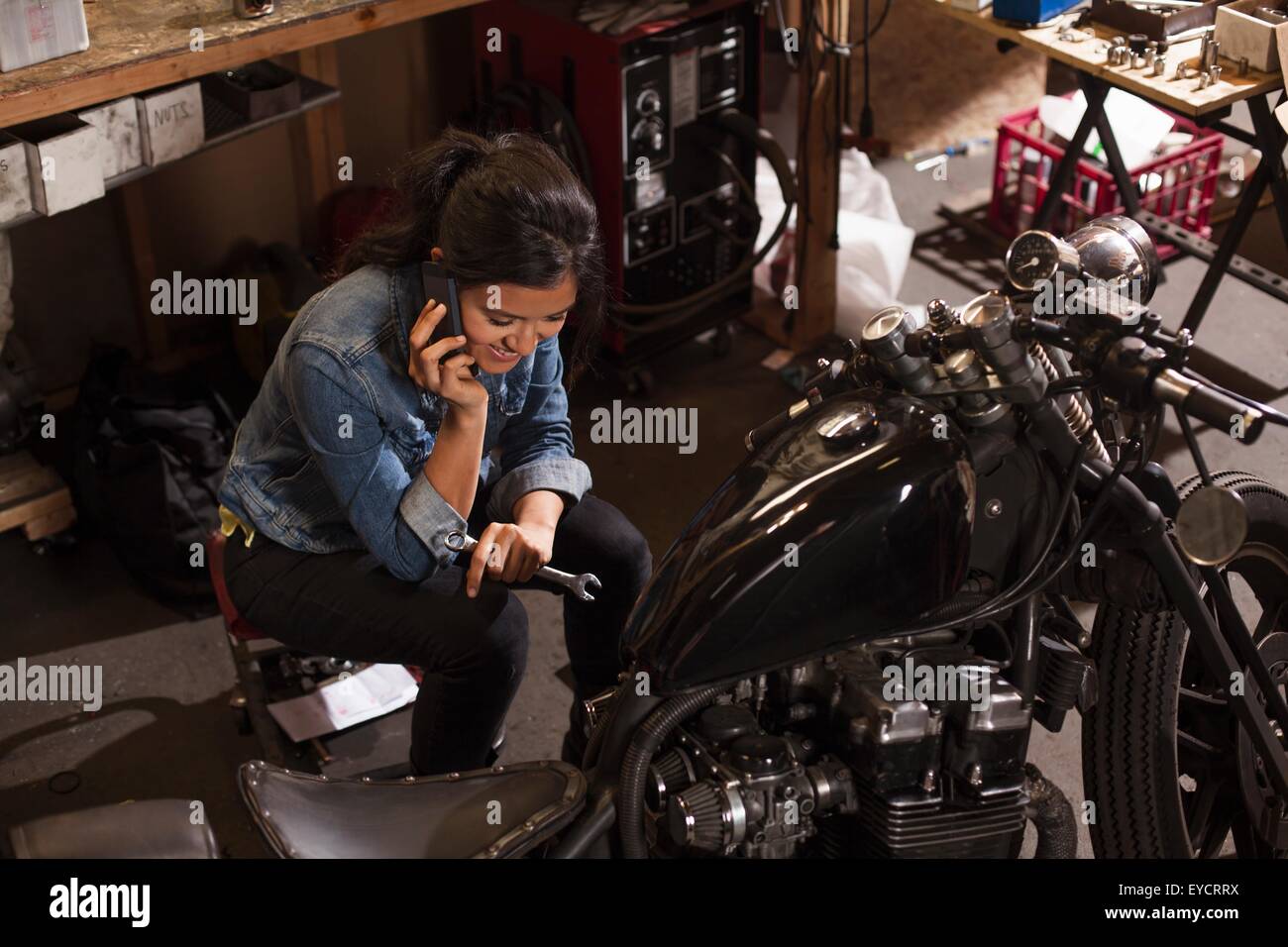 Female mechanic using mobile phone in workshop Stock Photo - Alamy