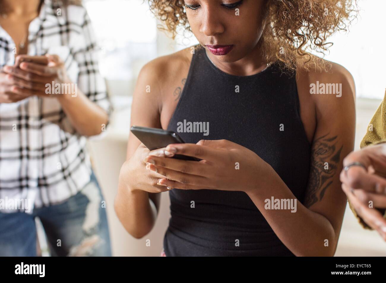 Young woman reading smartphone text in kitchen Stock Photo - Alamy