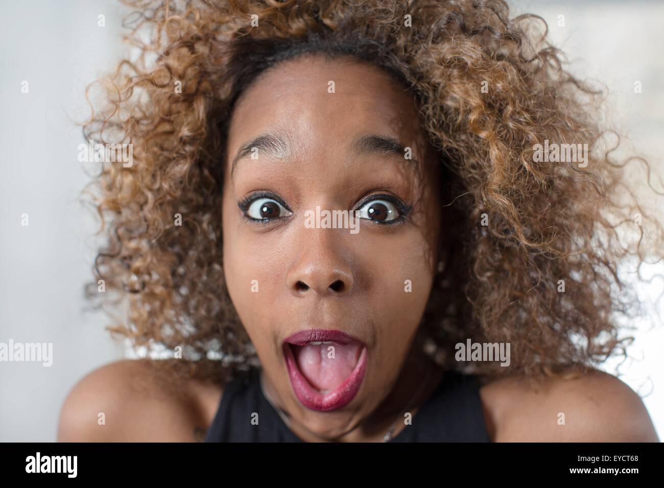 Portrait of young woman pulling a face with mouth open Stock Photo - Alamy