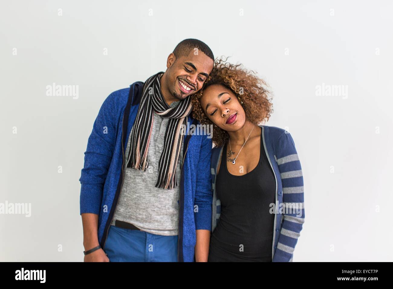 Studio portrait of romantic couple with heads on each others shoulder ...
