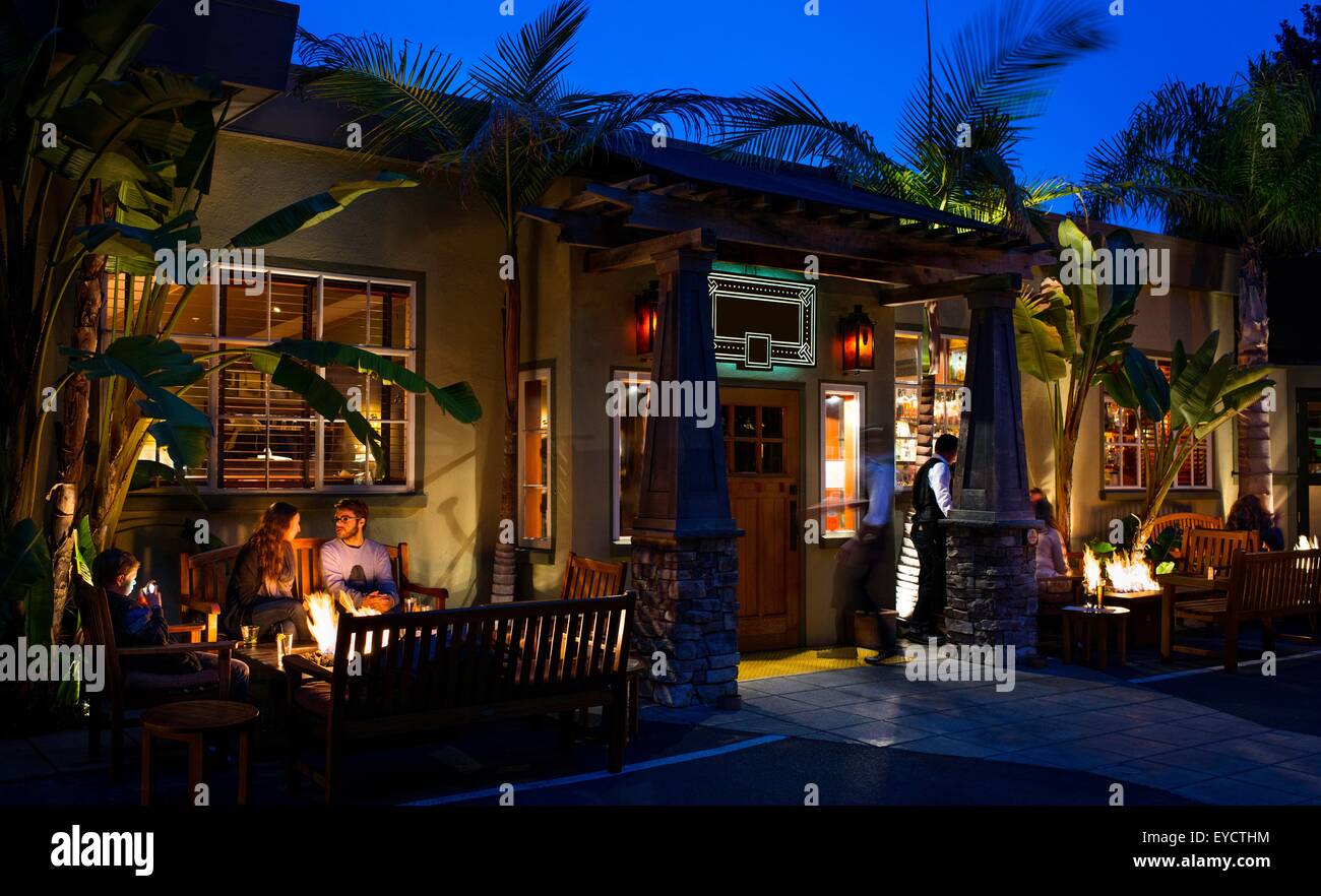 Customers dining out by restaurant open fire Stock Photo - Alamy