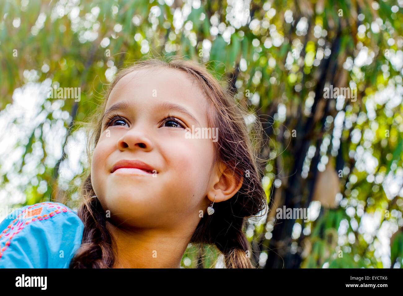 Low angle view of pretty girl in garden Stock Photo - Alamy