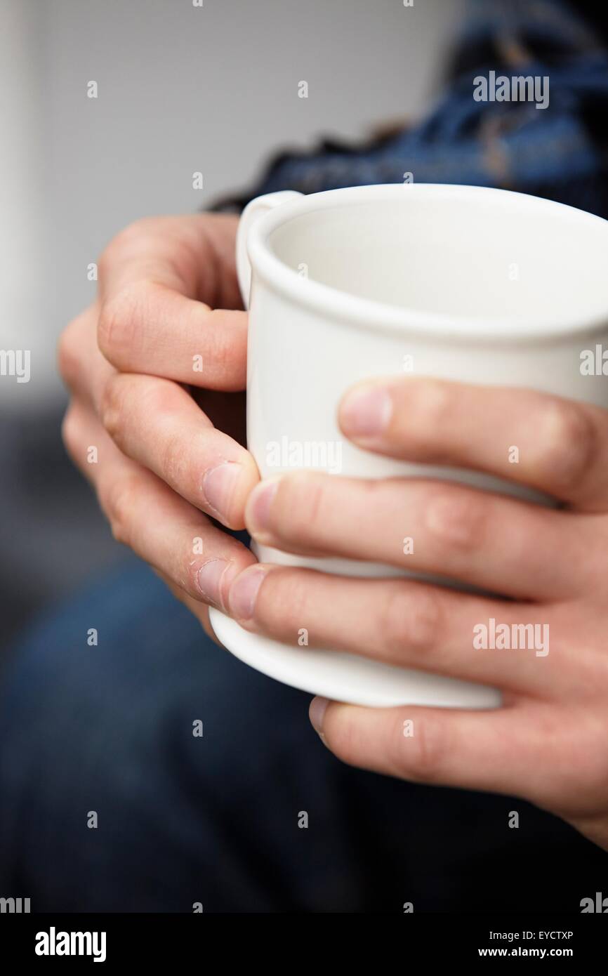 Close up of young mans hands holding coffee mug Stock Photo - Alamy