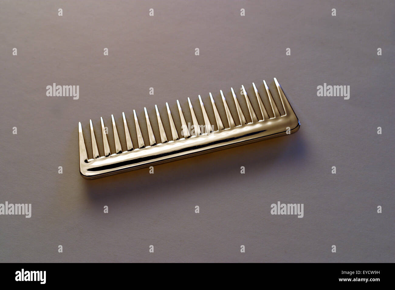 A gold hair comb isolated against a light grey cyclorama Stock Photo ...